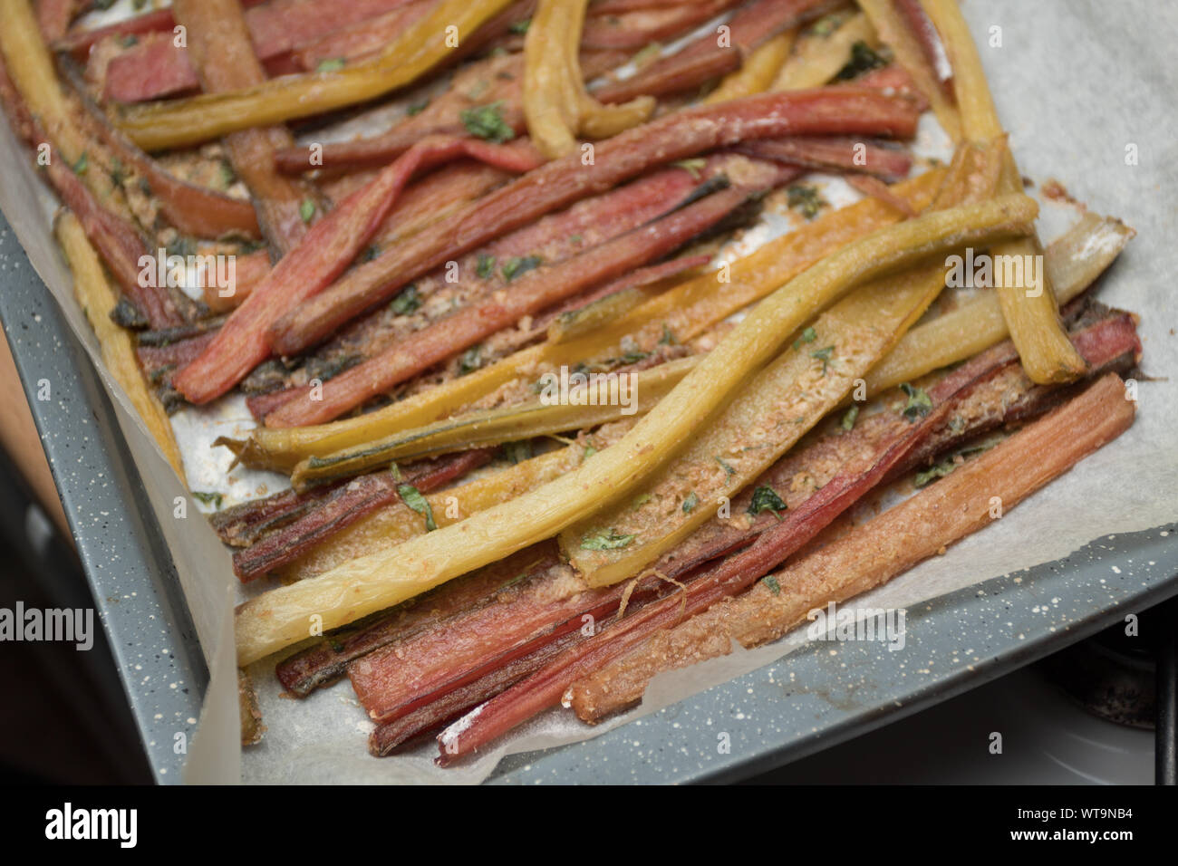 Tray of oven roasted chard gratin with Italian herbs on cooker top ...