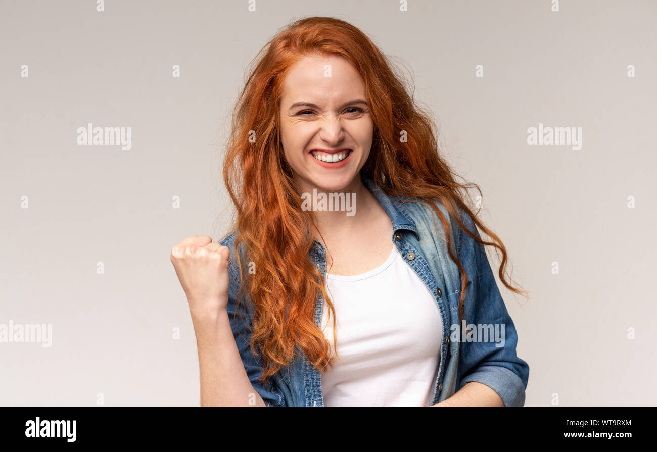 Euphoric girl celebrating victory over light studio background Stock ...