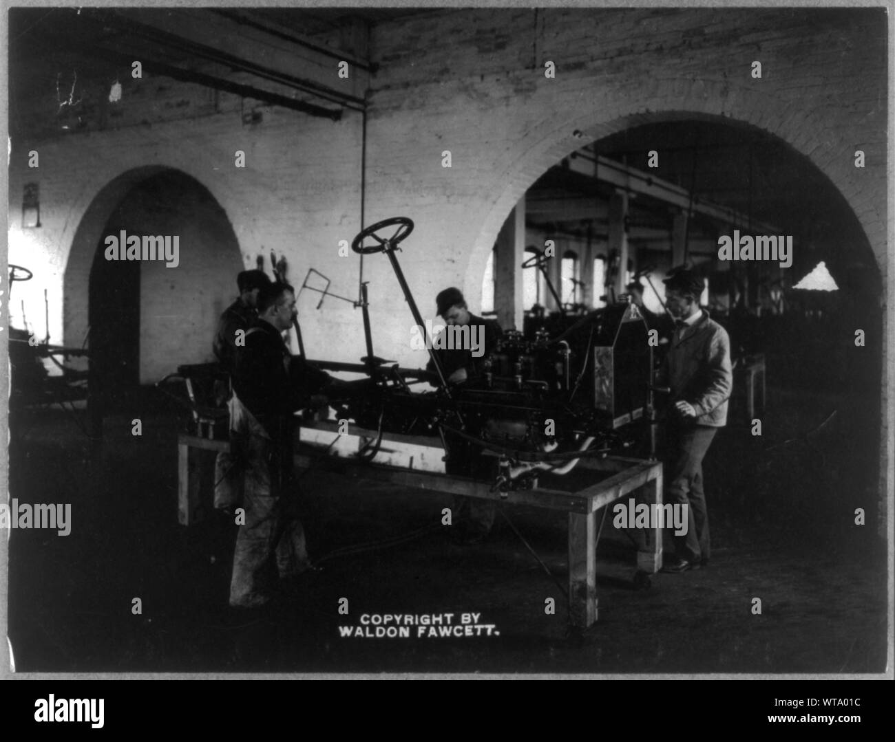 Men assembling auto in a plant Stock Photo - Alamy