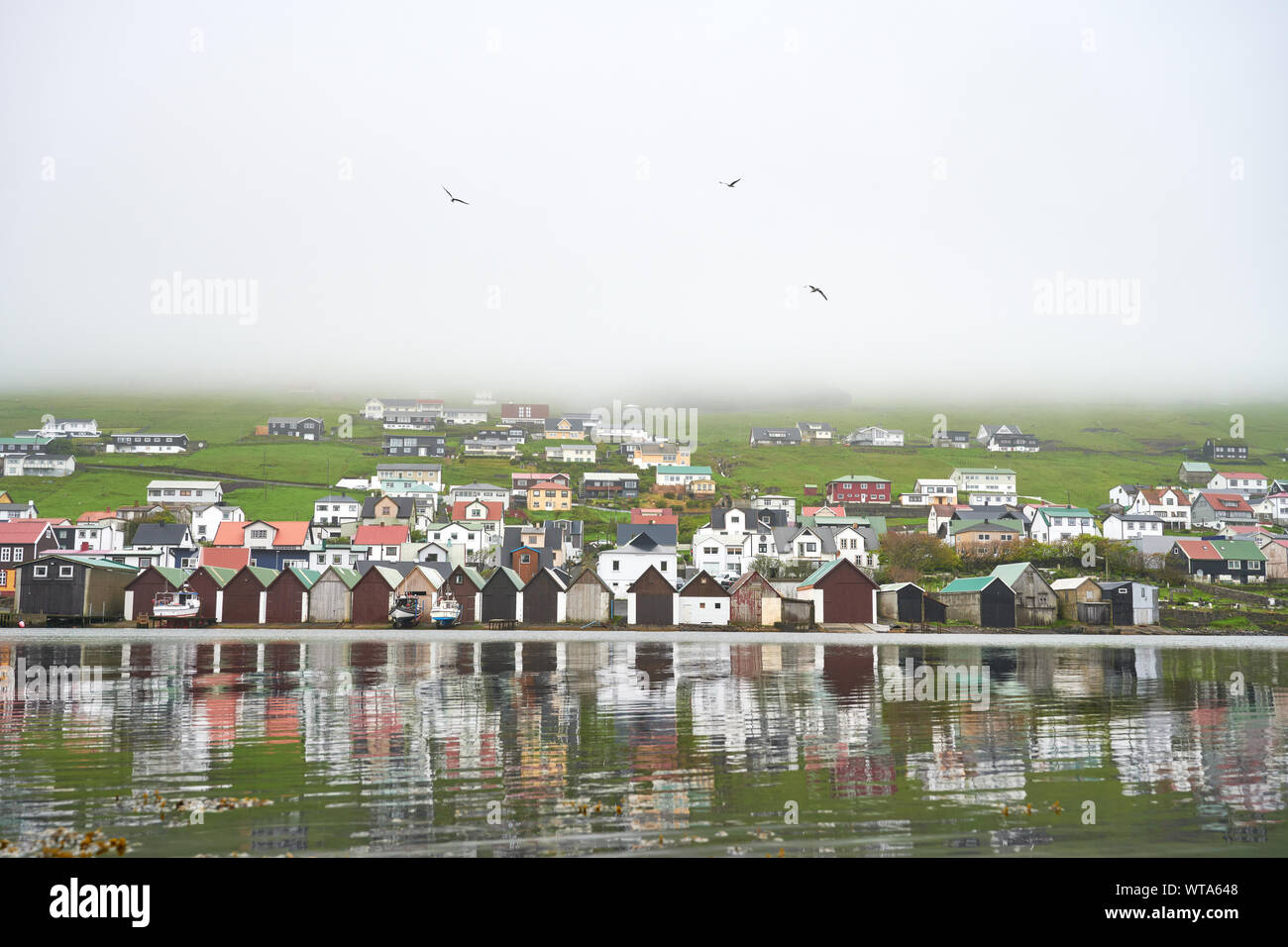 Settlement on shore of lake on misty field on Faroe Islands Stock Photo ...