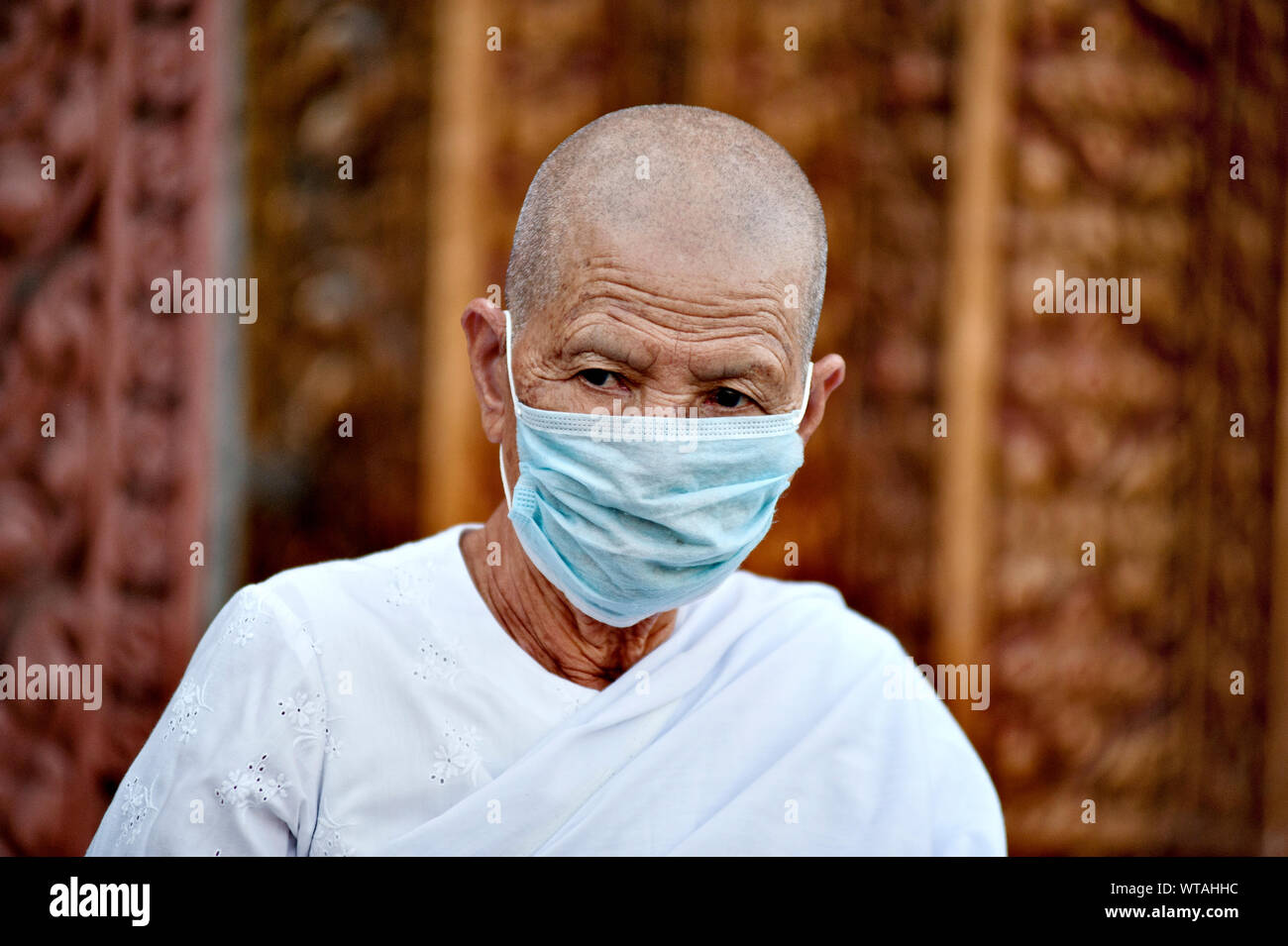 Old religious woman wears anti-pollution mask in the streets Stock ...