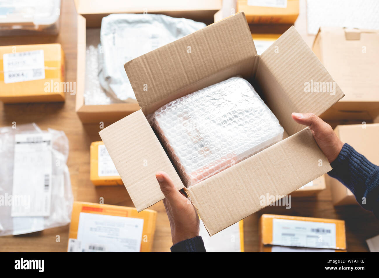 Online shopping concepts with male hand packing some product to brown ...