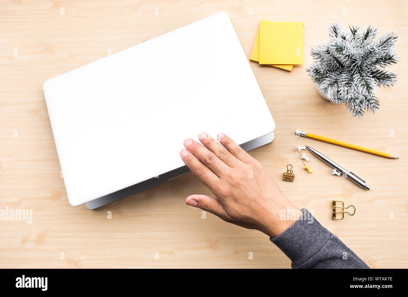 Young man closing computer laptop with accessories object on wood desk ...