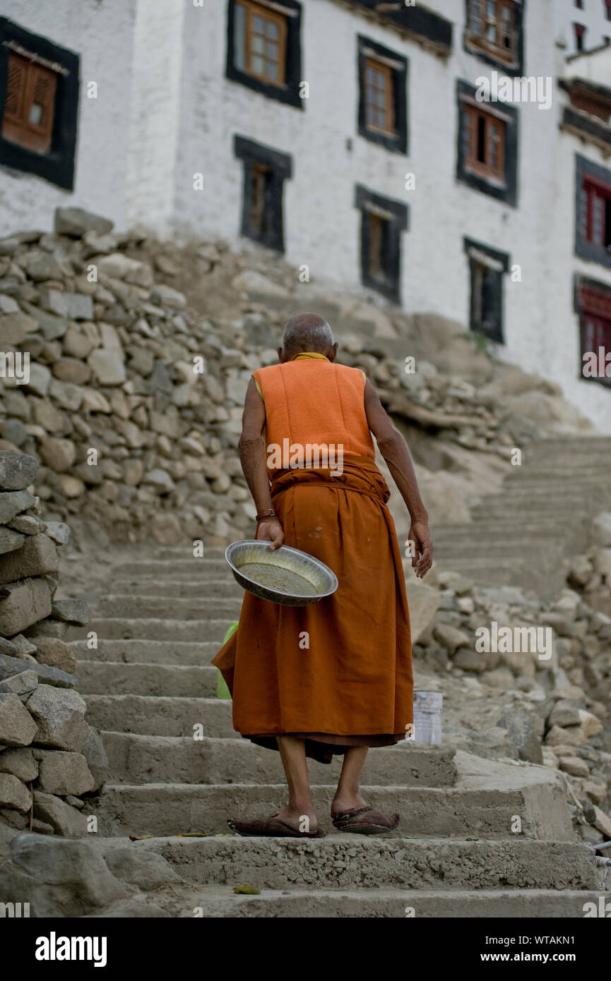 Old monk carrying a tray walking up the monastery ladder Stock Photo ...