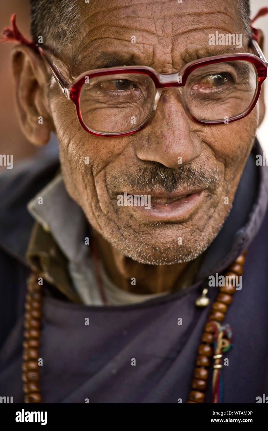 Old Buddhist man with typical garment and glasses Stock Photo - Alamy