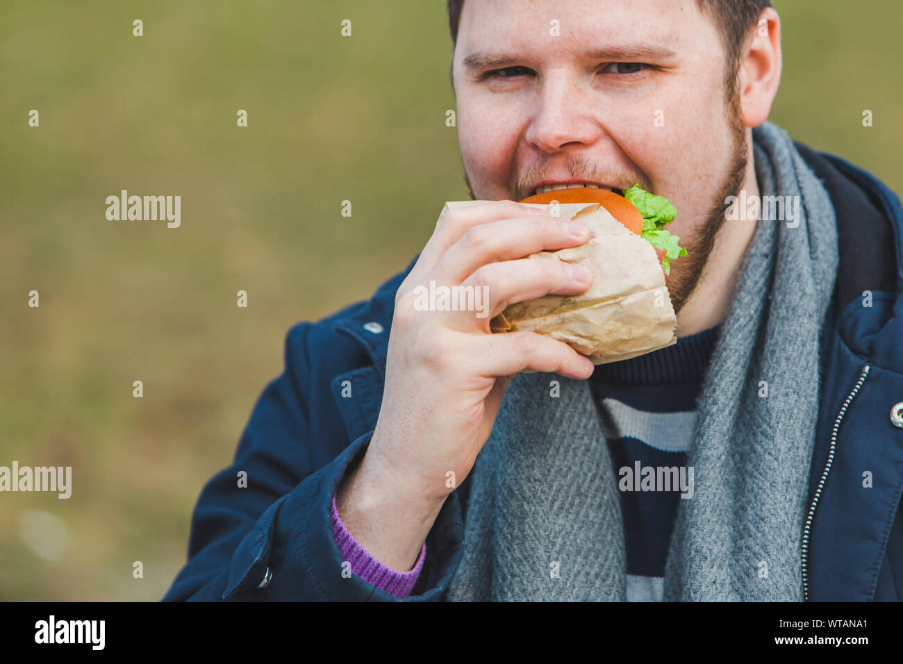 young adult man eating hamburger Stock Photo - Alamy