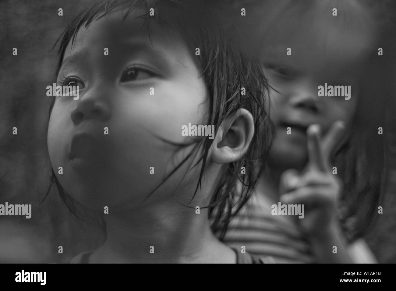Young Thai boys looking through bush foliage Stock Photo - Alamy