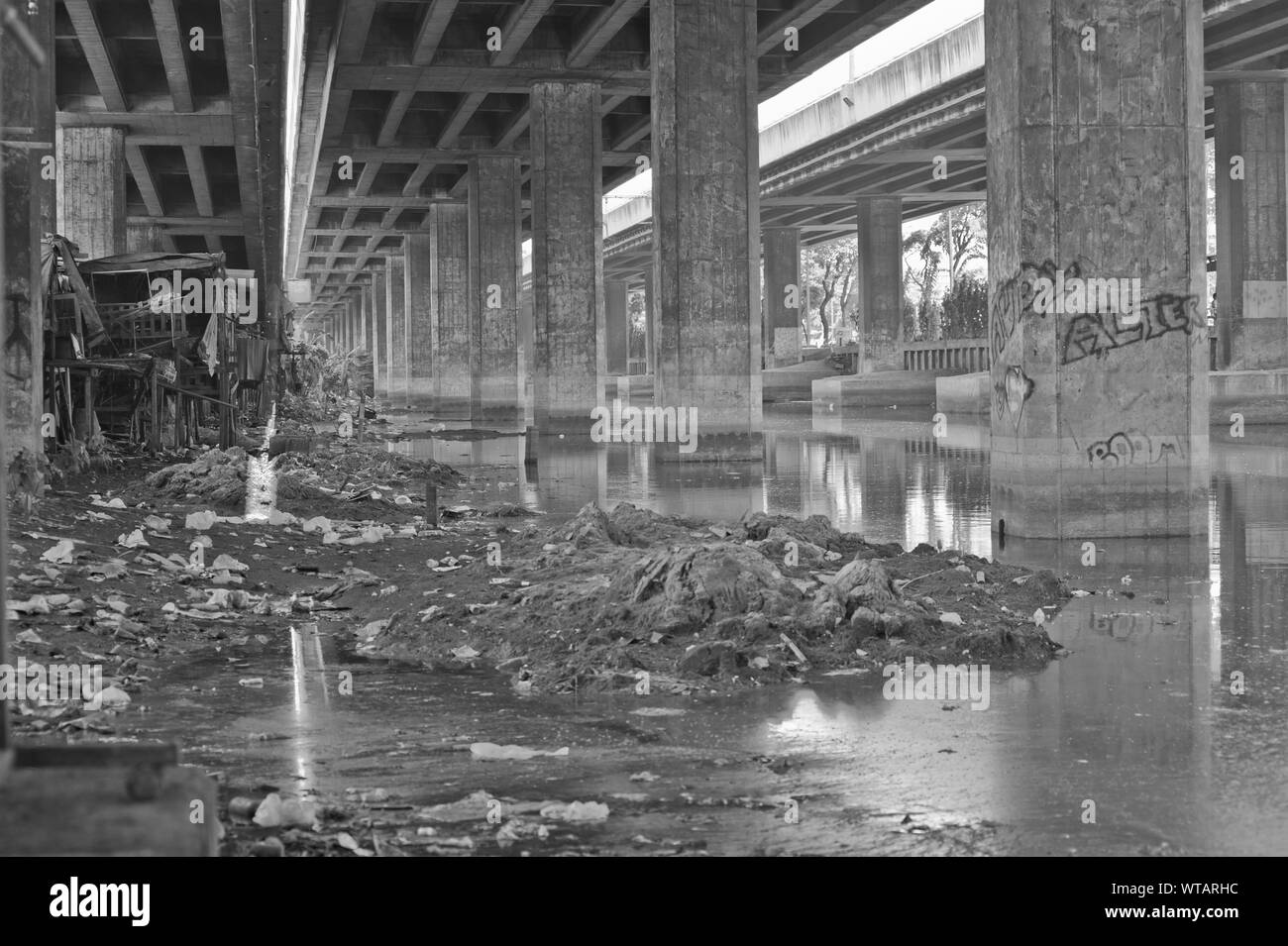 Slum under the overpass viaduct by the sewer system Stock Photo - Alamy