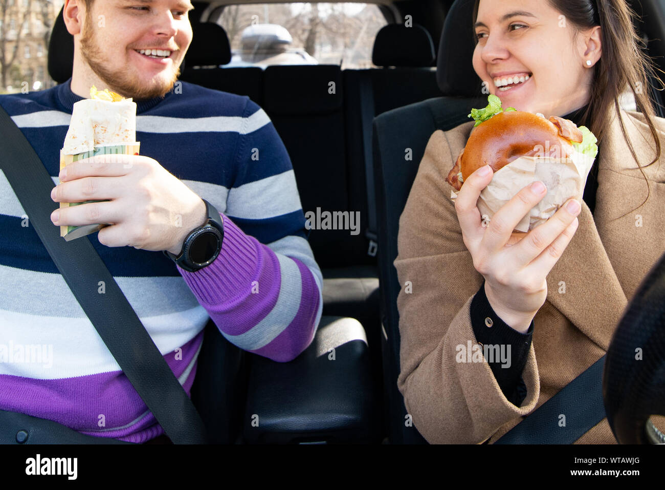 young couple eating fast food in car Stock Photo - Alamy