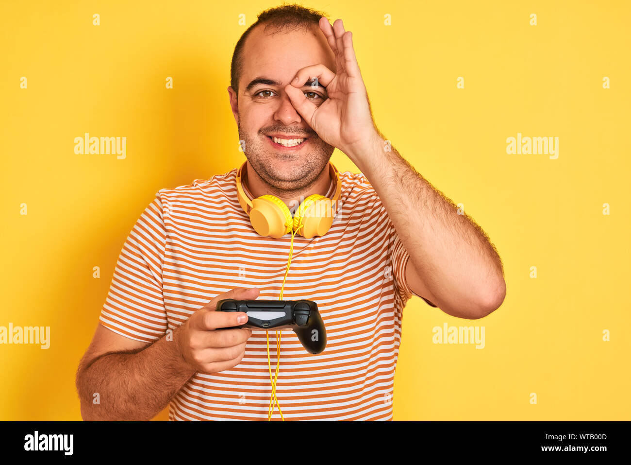 Young gamer man playing video game using headphones over isolated ...