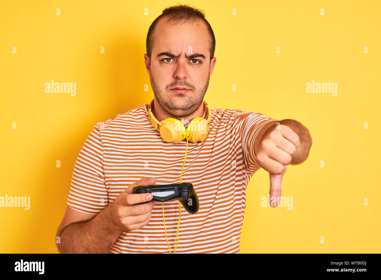 Young gamer man playing video game using headphones over isolated ...