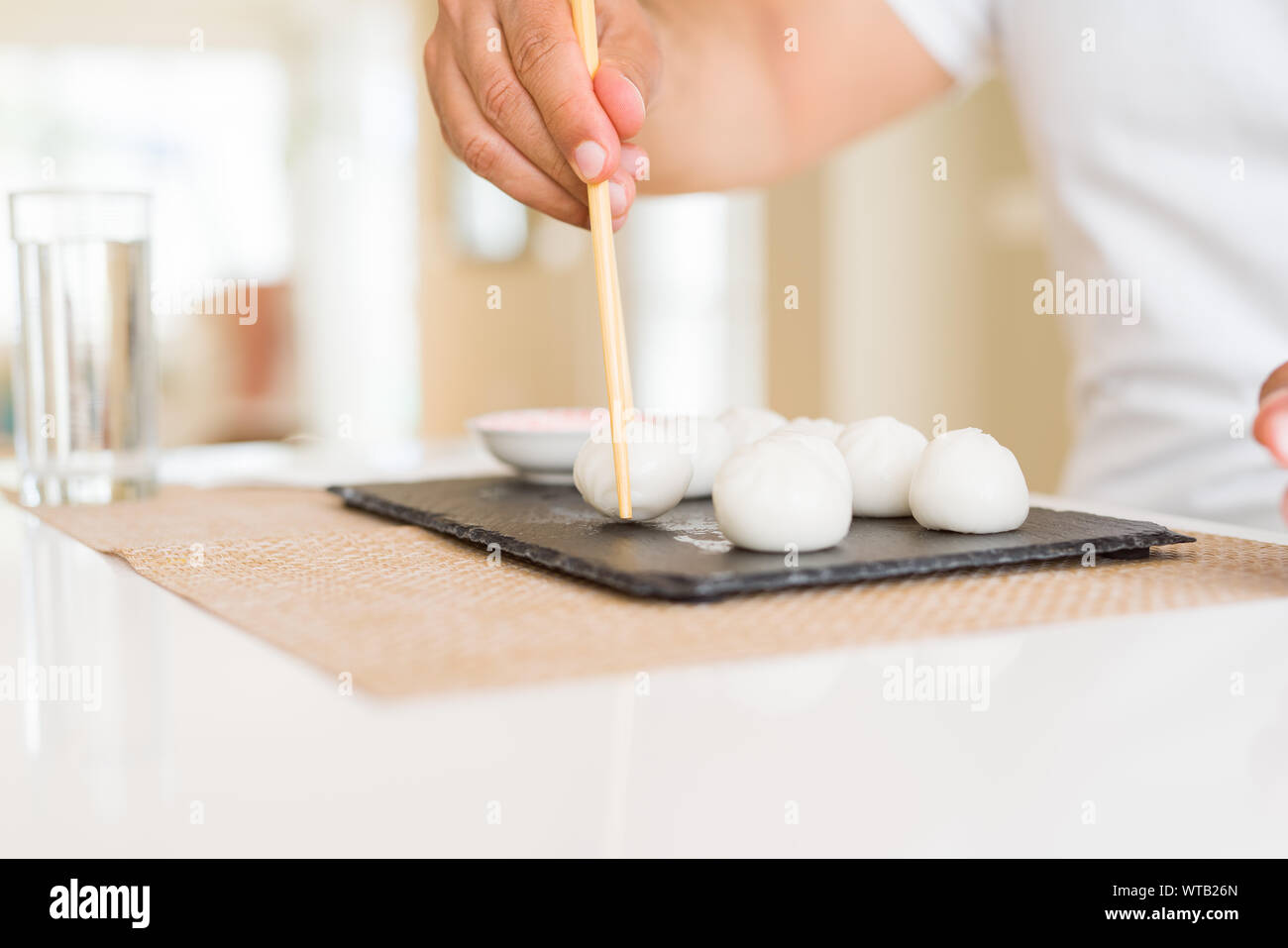 Middle age man eating asian dim sum using chopsticks at home Stock ...