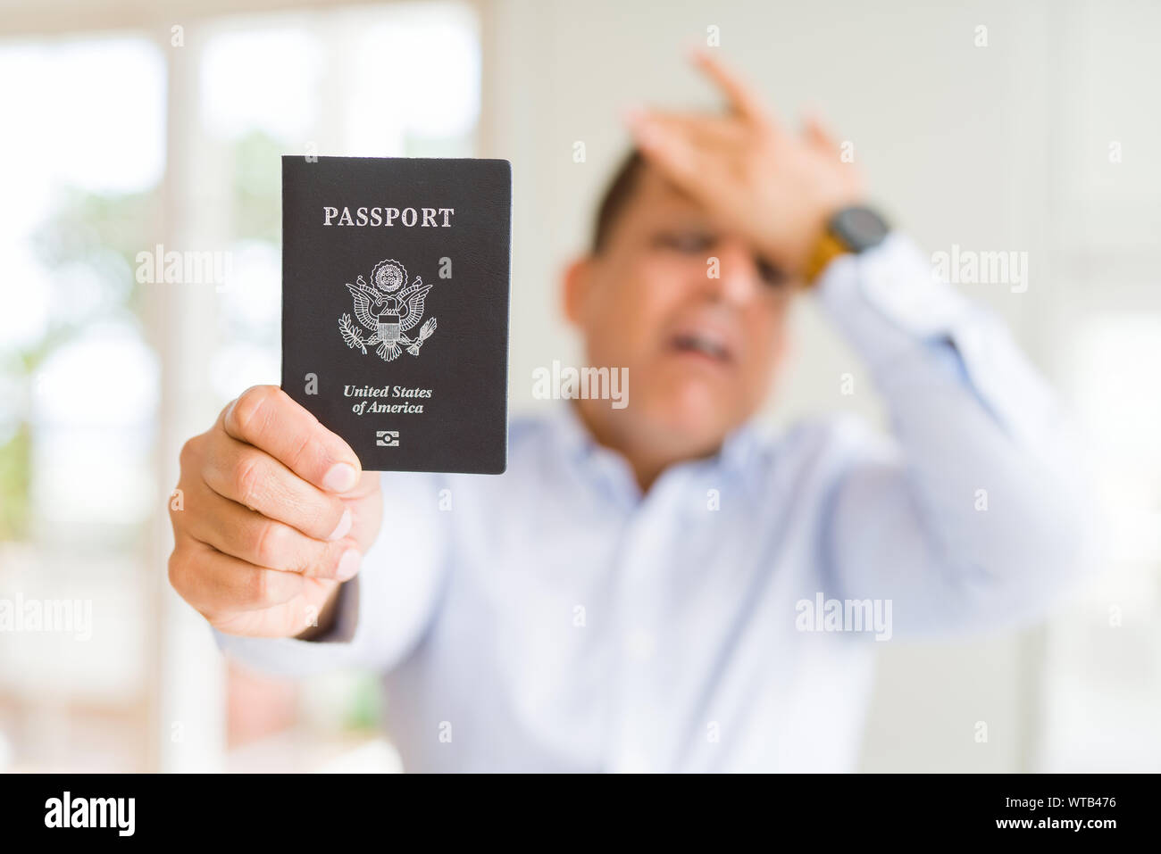 Middle age man holding holding passport of United States stressed with ...
