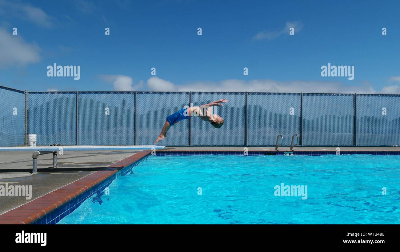 Boy Jumping Into Swimming Pool Stock Photo - Alamy