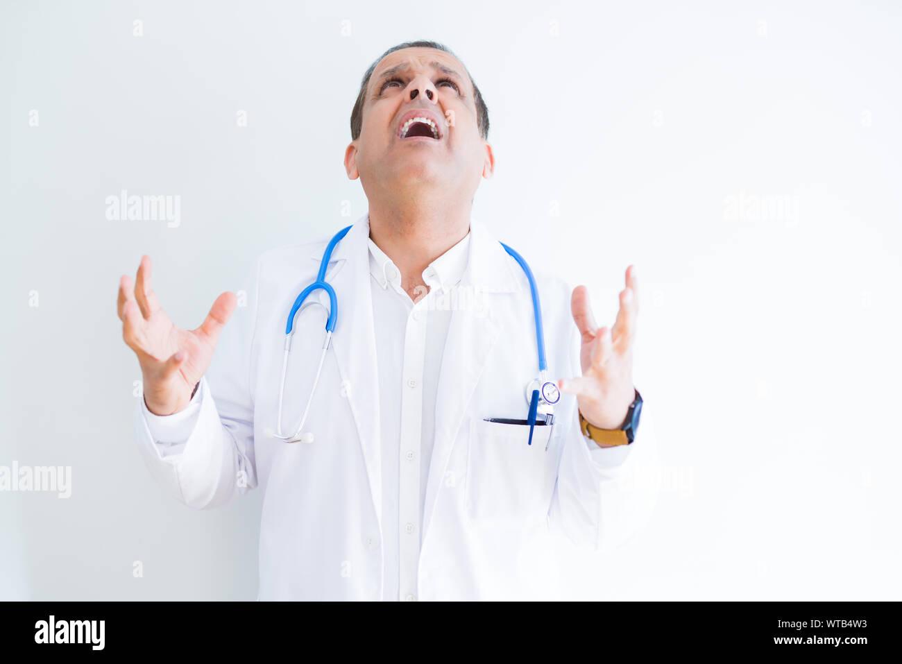 Middle age doctor man wearing stethoscope and medical coat over white ...