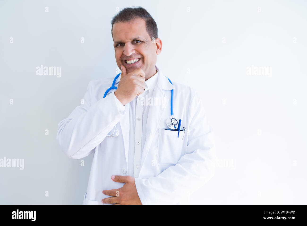 Middle age doctor man wearing stethoscope and medical coat over white ...