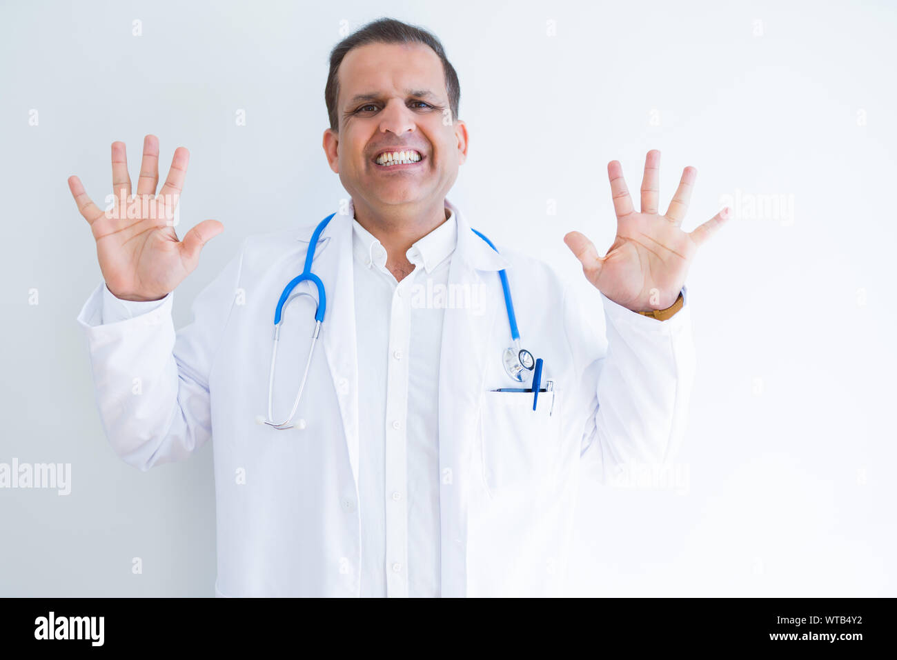 Middle age doctor man wearing stethoscope and medical coat over white ...