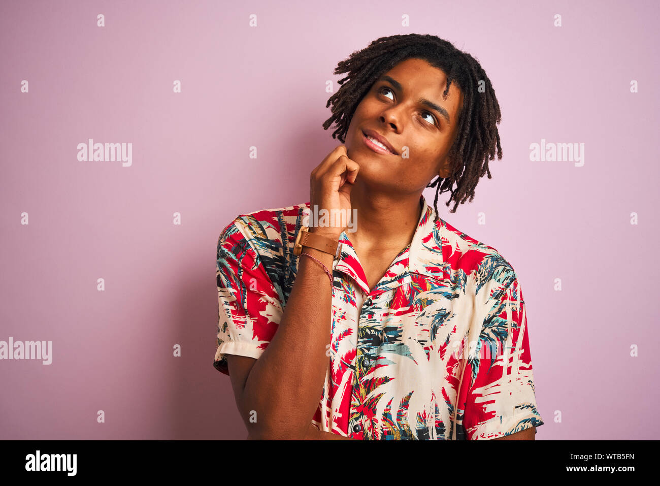 Afro man with dreadlocks on vacation wearing floral shirt over isolated ...
