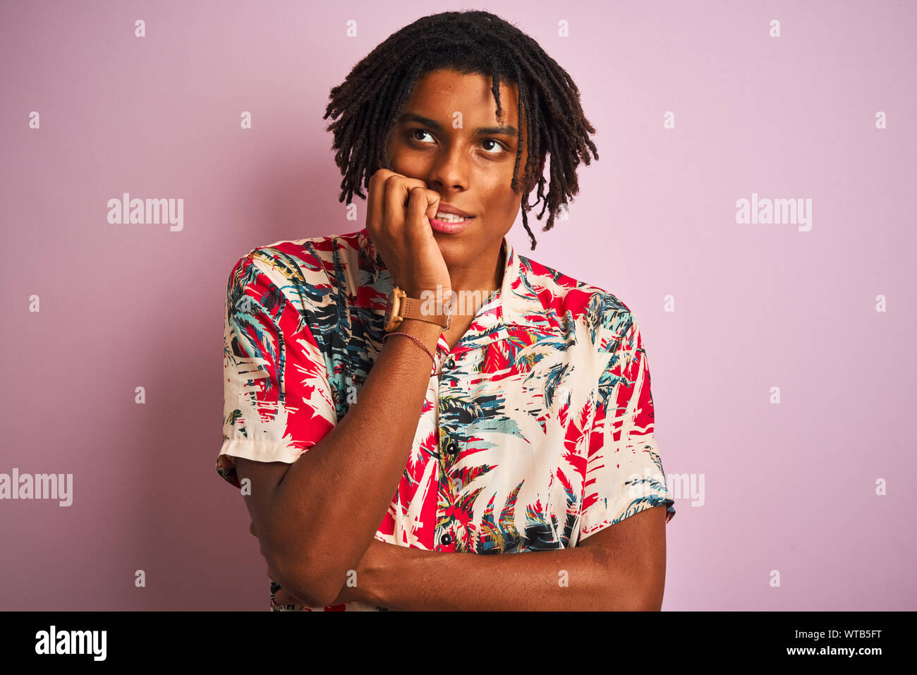 Afro man with dreadlocks on vacation wearing floral shirt over isolated ...