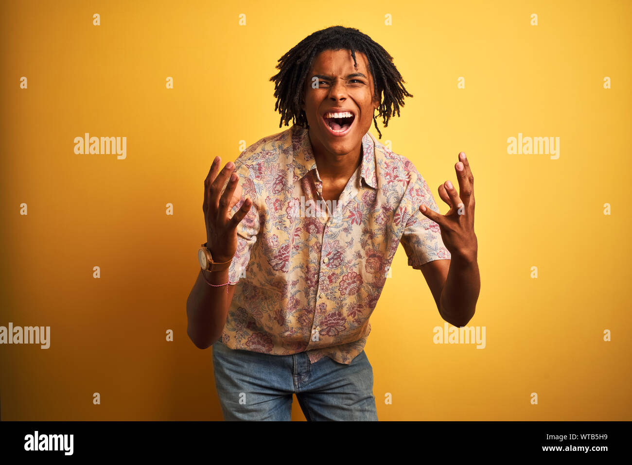 Afro man with dreadlocks on vacation wearing floral shirt over isolated ...