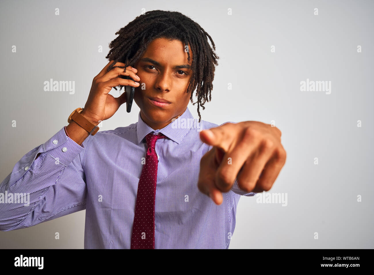 Afro businessman with dreadlocks talking using smartphone over isolated ...