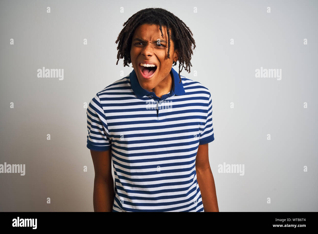 Afro man with dreadlocks wearing striped blue polo standing over ...