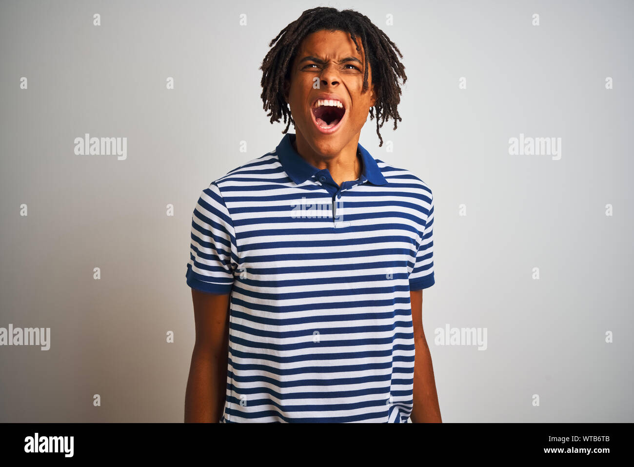 Afro man with dreadlocks wearing striped blue polo standing over ...