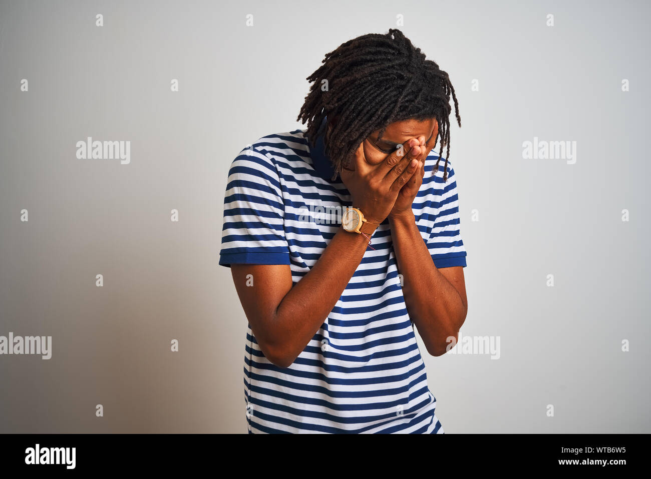 Afro man with dreadlocks wearing striped blue polo standing over ...