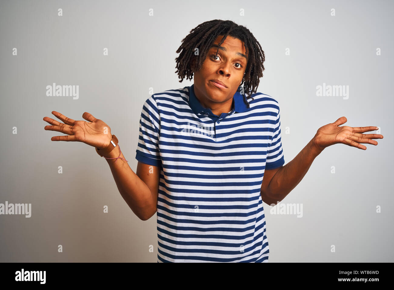 Afro man with dreadlocks wearing striped blue polo standing over ...