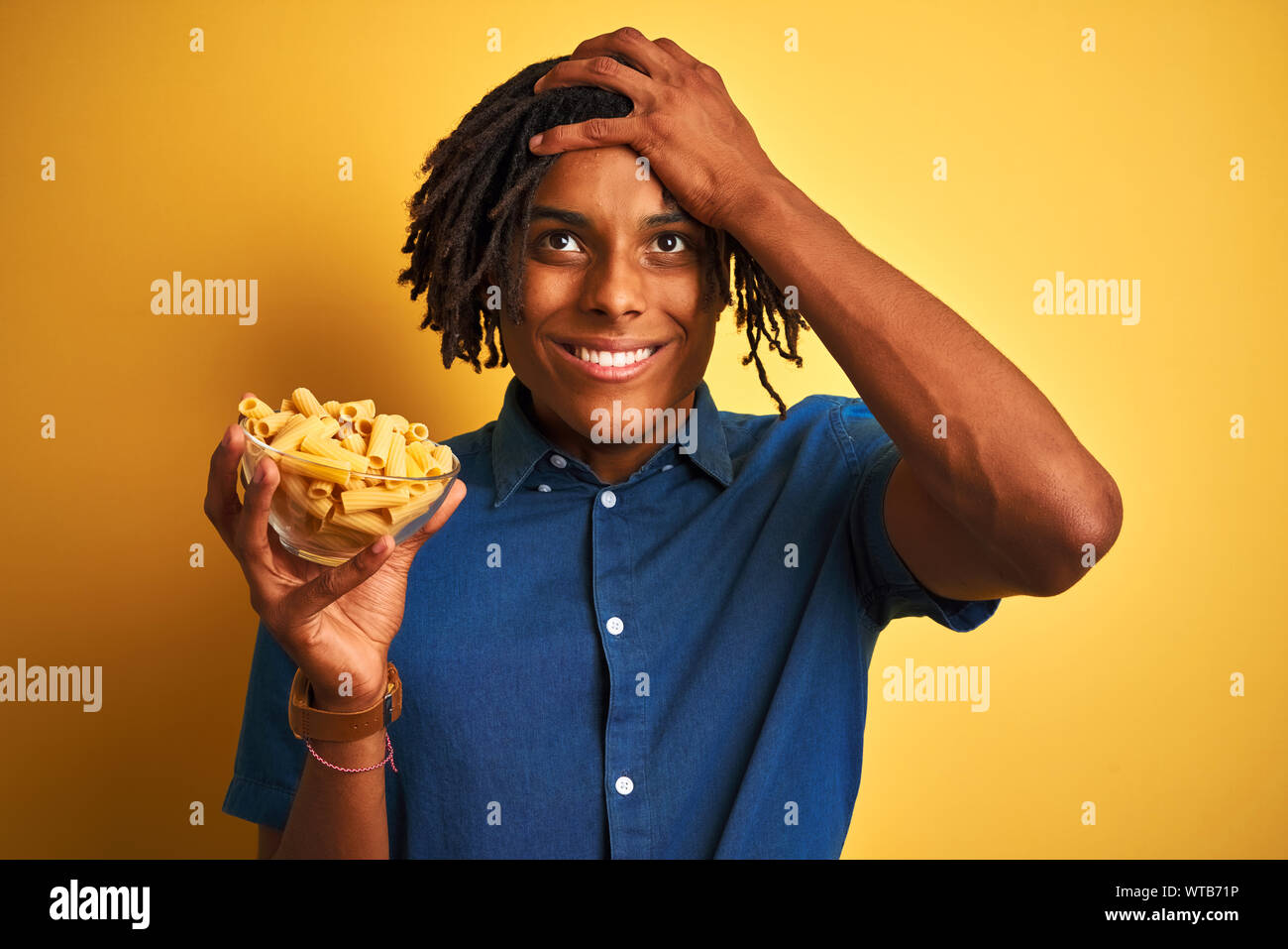 Afro american man with dreadlocks holding pasta macaroni over isolated ...