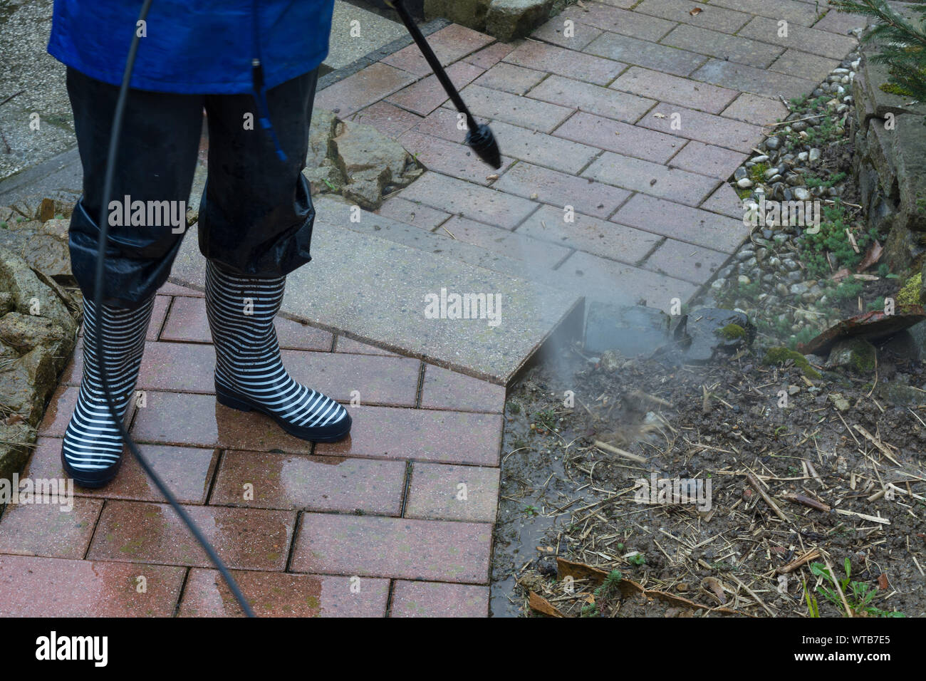 Woman cleans stone slabs with a pressure washer Stock Photo - Alamy