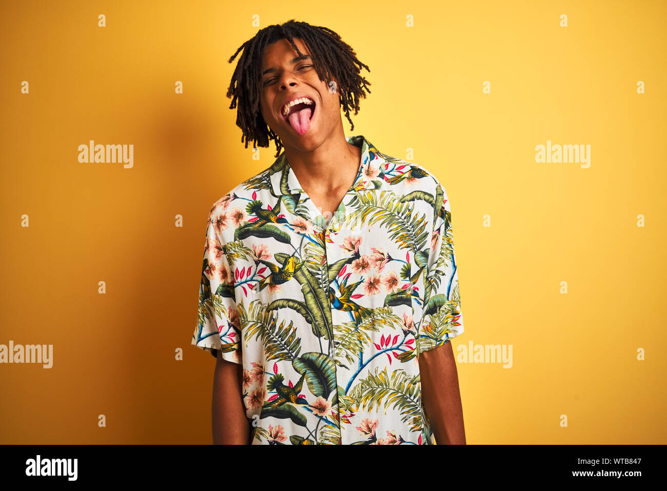 Afro man with dreadlocks on vacation wearing summer shirt over isolated ...
