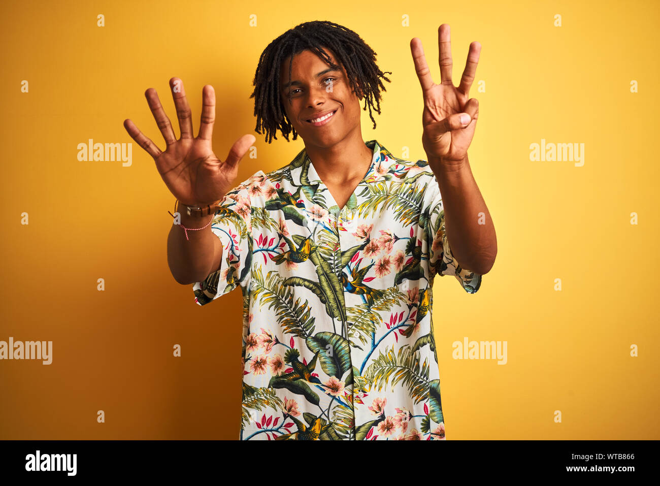 Afro man with dreadlocks on vacation wearing summer shirt over isolated ...