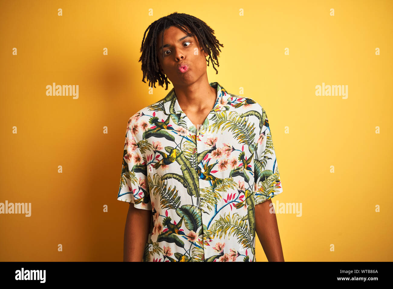 Afro man with dreadlocks on vacation wearing summer shirt over isolated ...