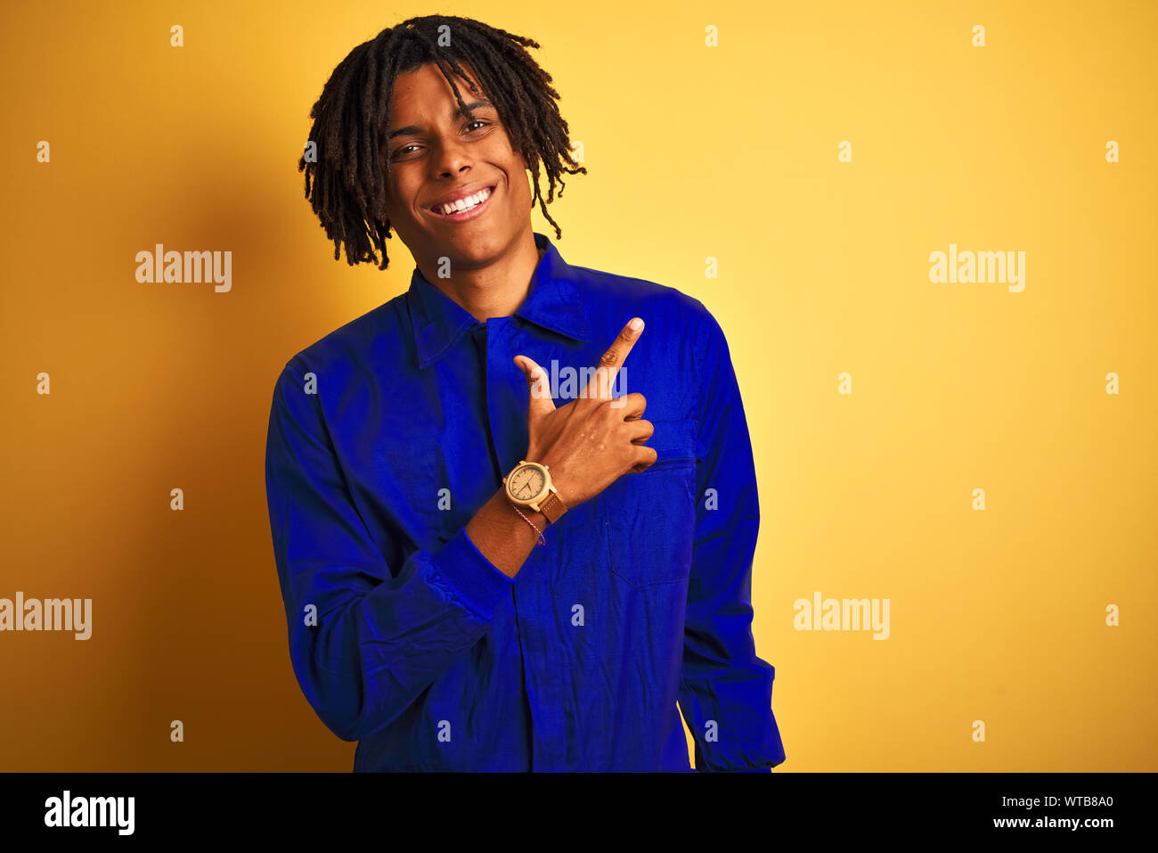 Afro worker man with dreadlocks wearing mechanic uniform over isolated ...