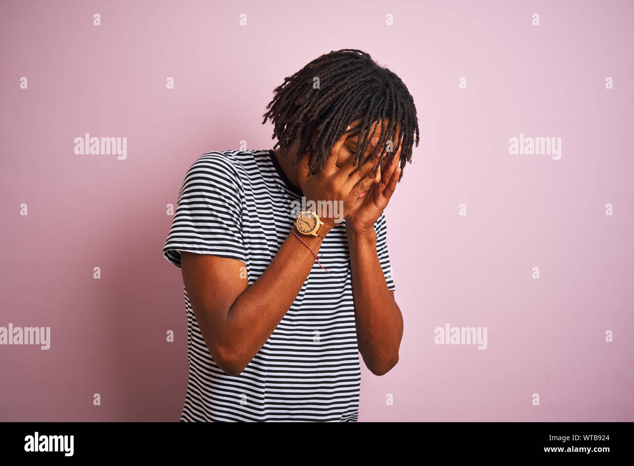 Afro man with dreadlocks wearing navy striped t-shirt standing over ...