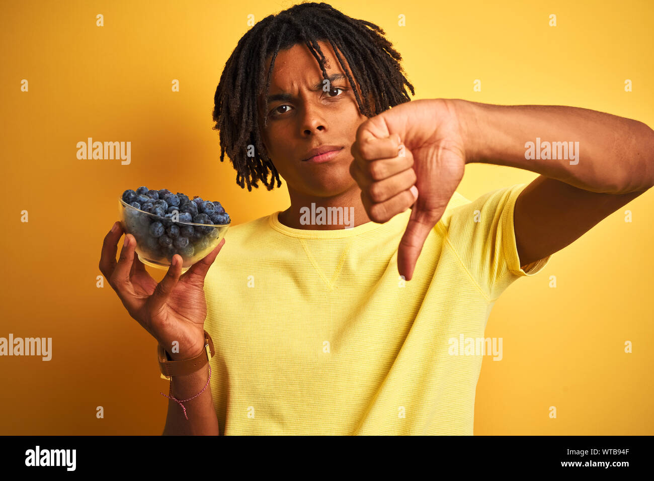 Afro american man with dreadlocks holding blueberries over isolated ...