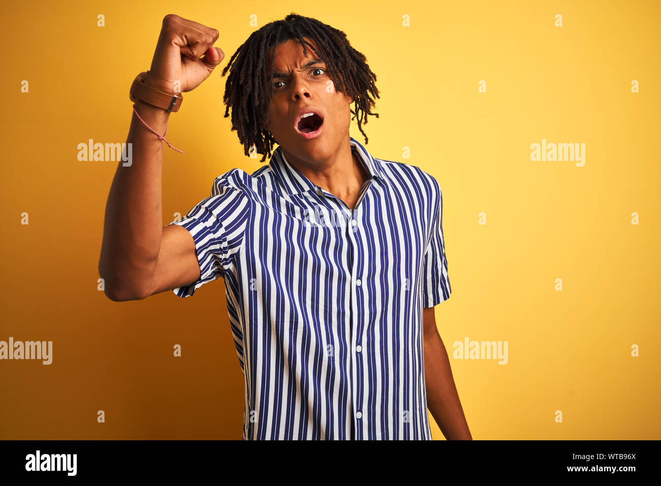 Afro man with dreadlocks wearing casual striped t-shirt over isolated ...