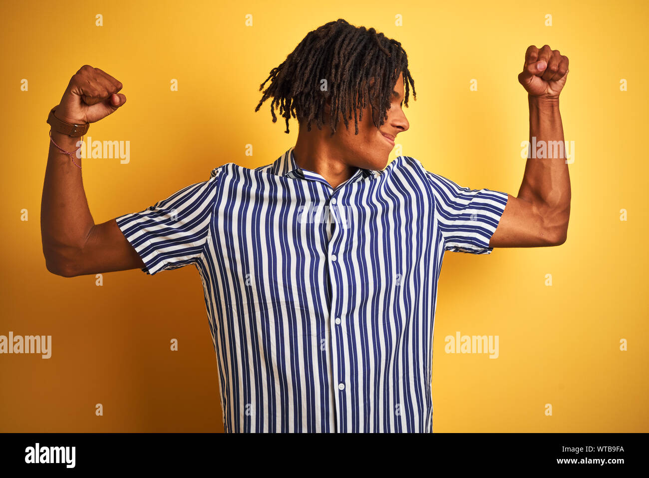 Afro man with dreadlocks wearing casual striped t-shirt over isolated ...