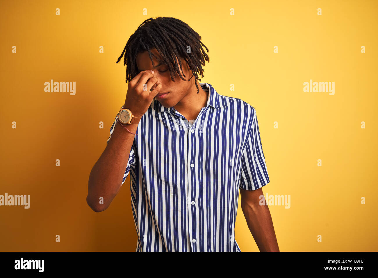 Afro man with dreadlocks wearing casual striped t-shirt over isolated ...