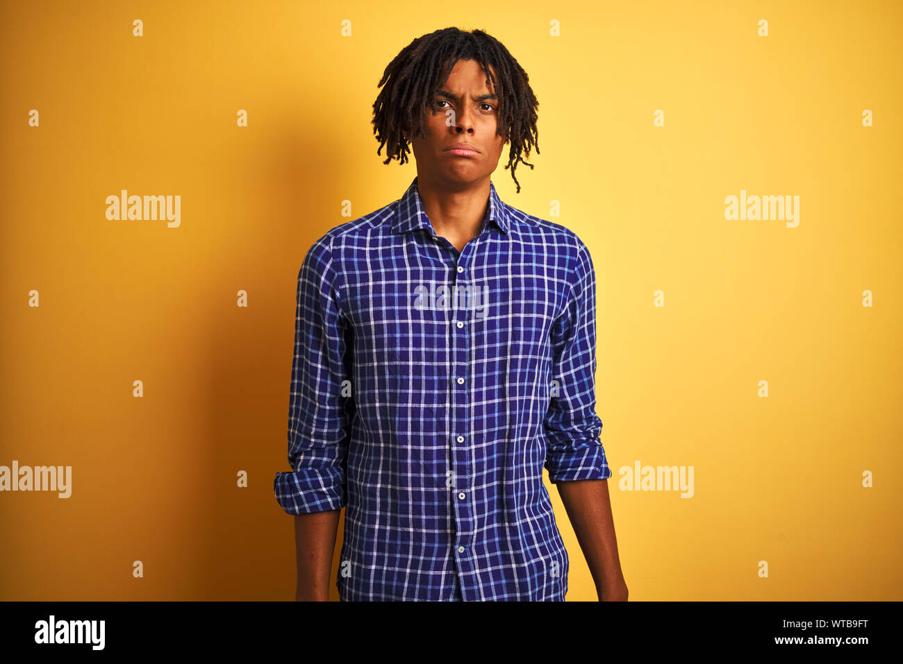 Afro man with dreadlocks wearing casual shirt standing over isolated ...