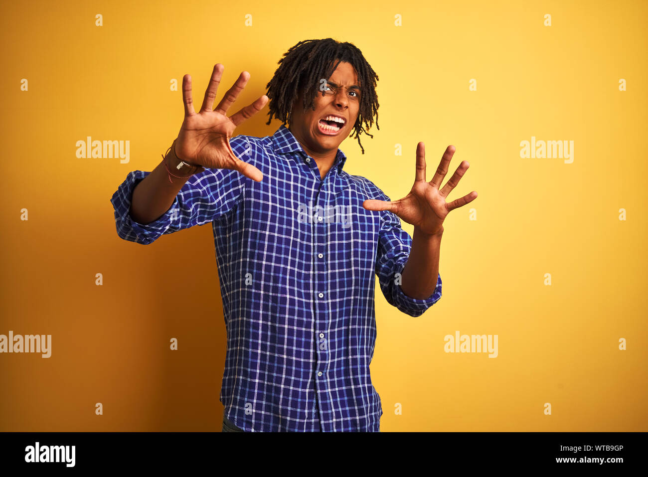 Afro man with dreadlocks wearing casual shirt standing over isolated ...