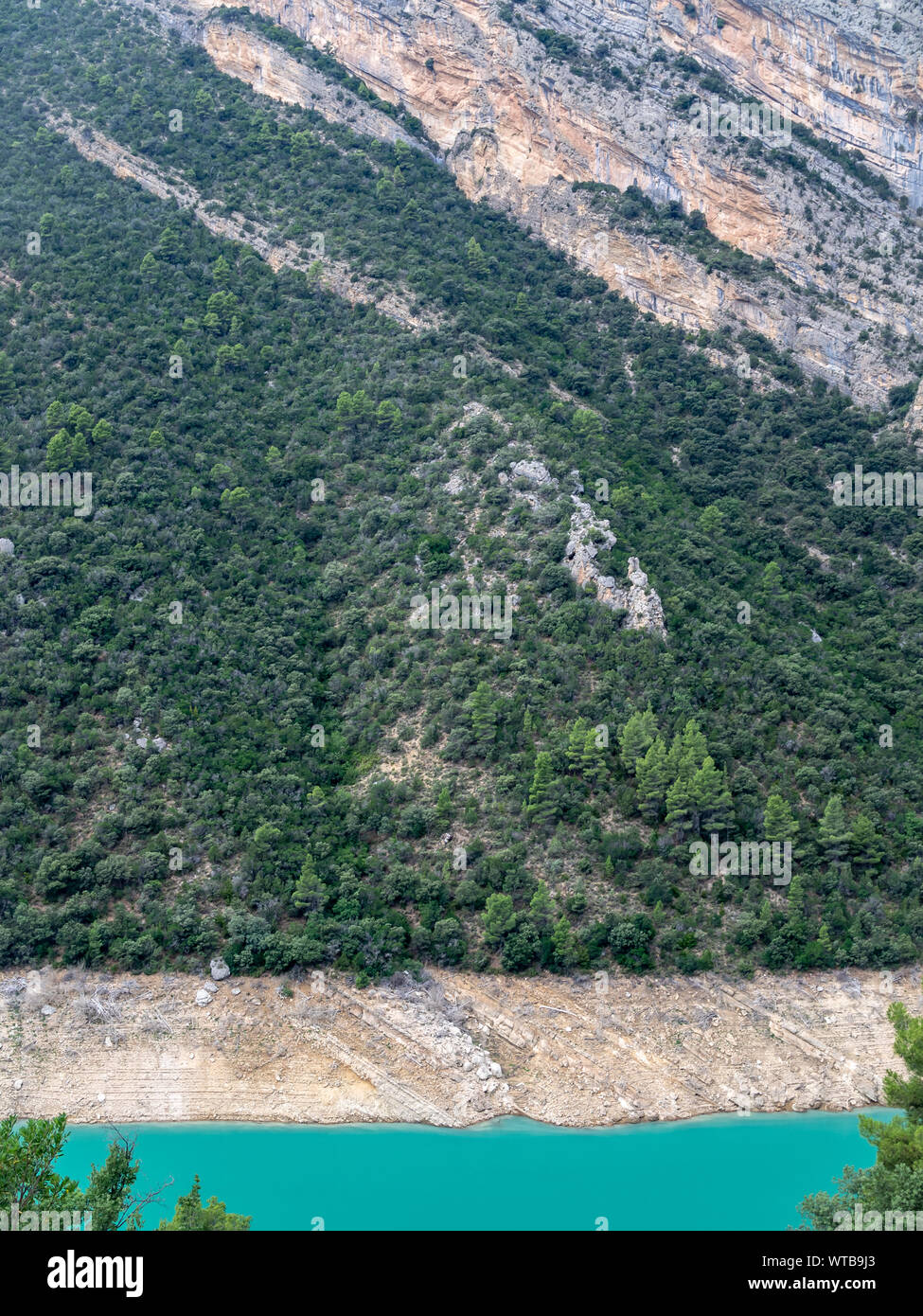 Diagonal real cliff with the forest and blue water river background ...