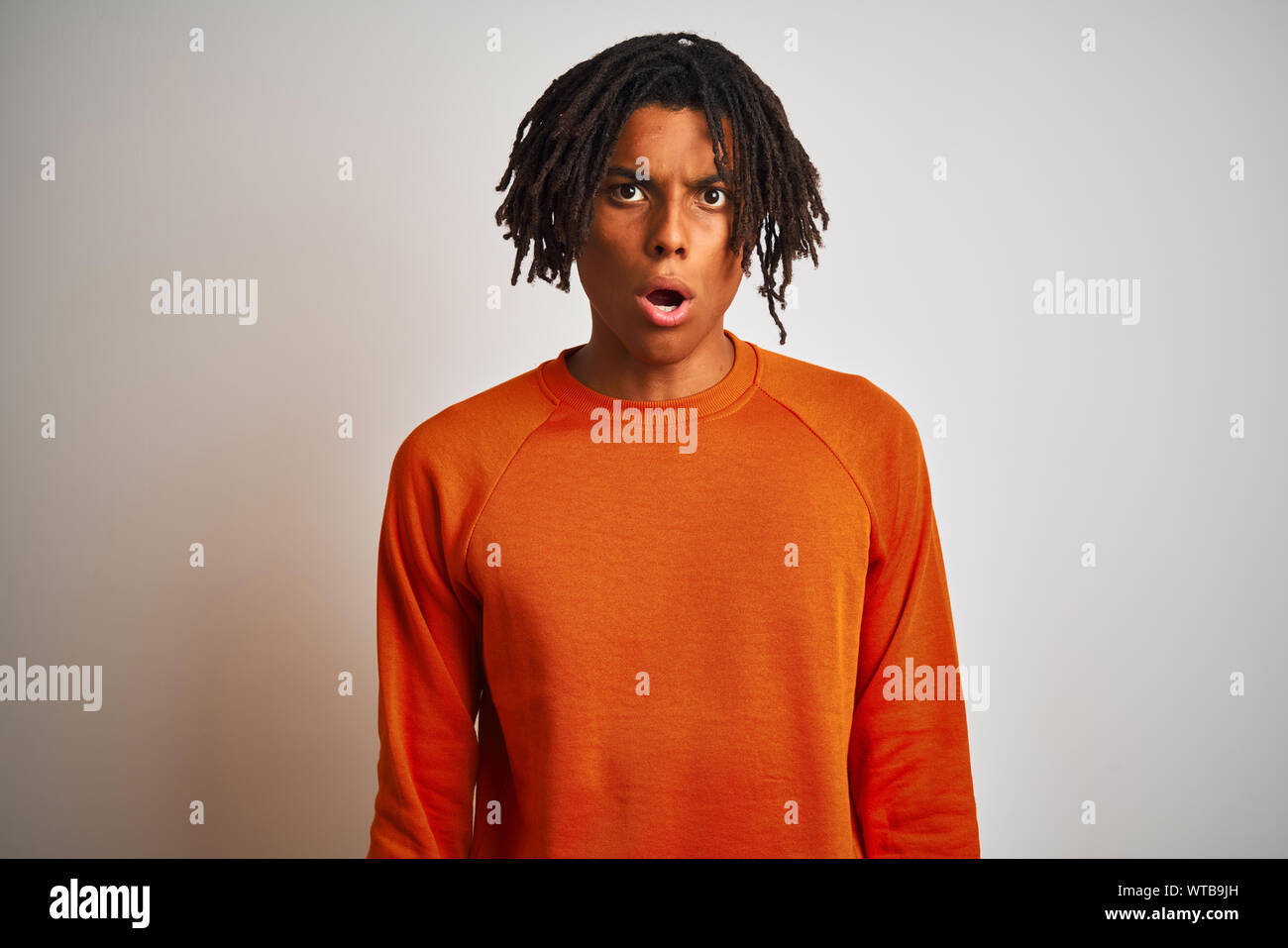 Afro american man with dreadlocks wearing orange sweater over isolated ...