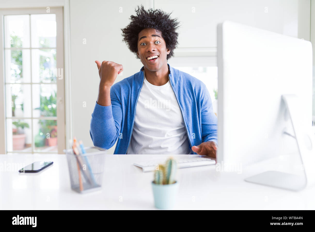 African American man working using computer pointing and showing with ...