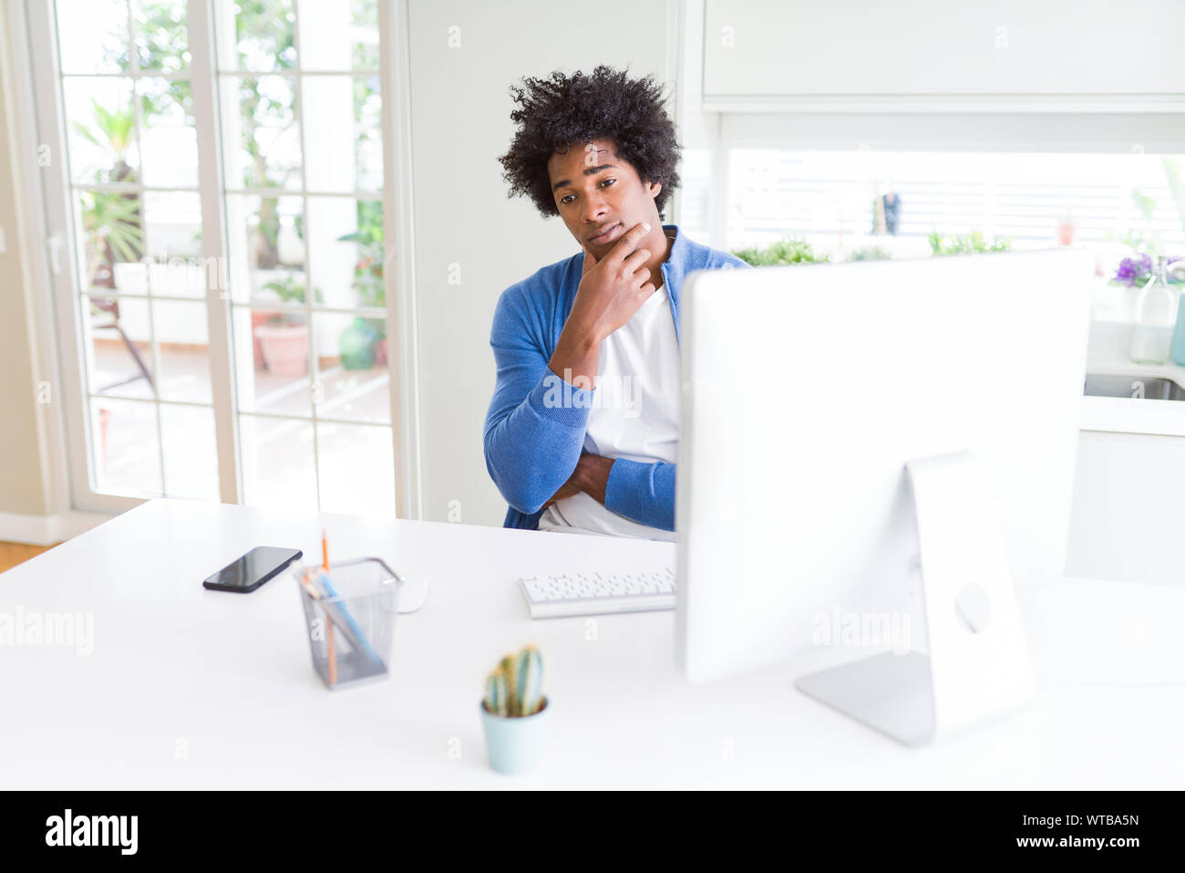 African American man working using computer thinking looking tired and ...