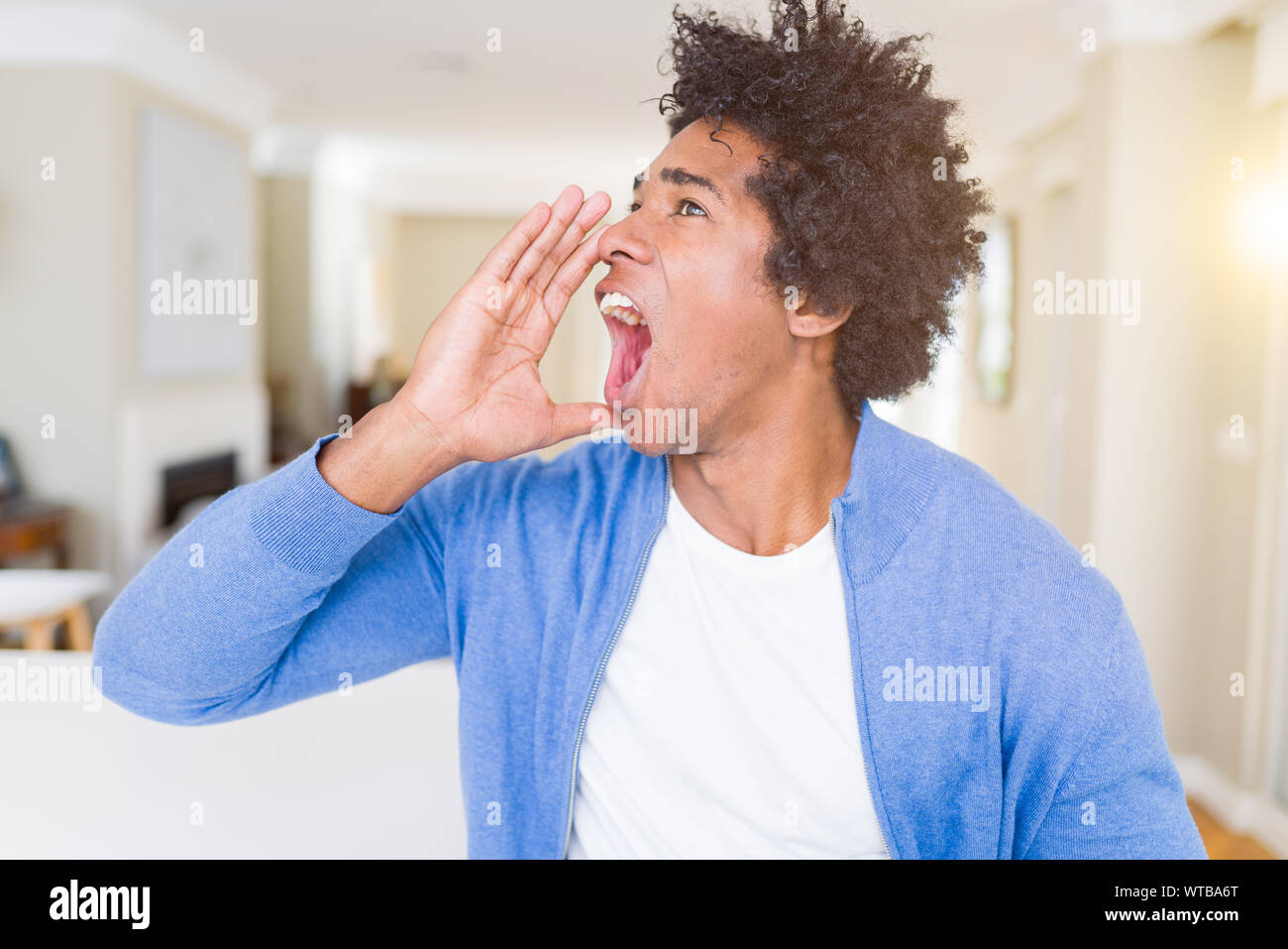 African American man at home shouting and screaming loud to side with ...