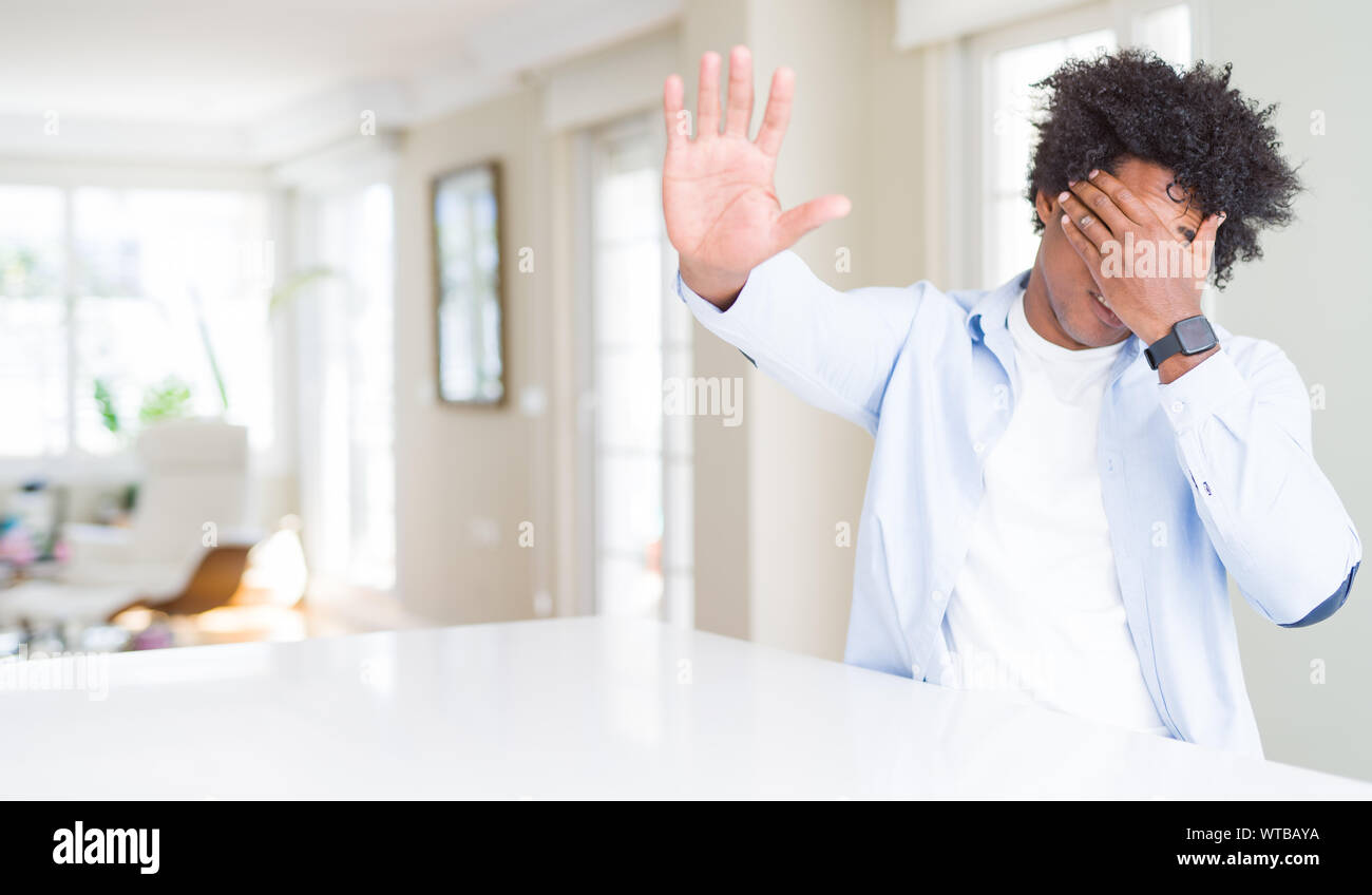 African American man at home covering eyes with hands and doing stop ...