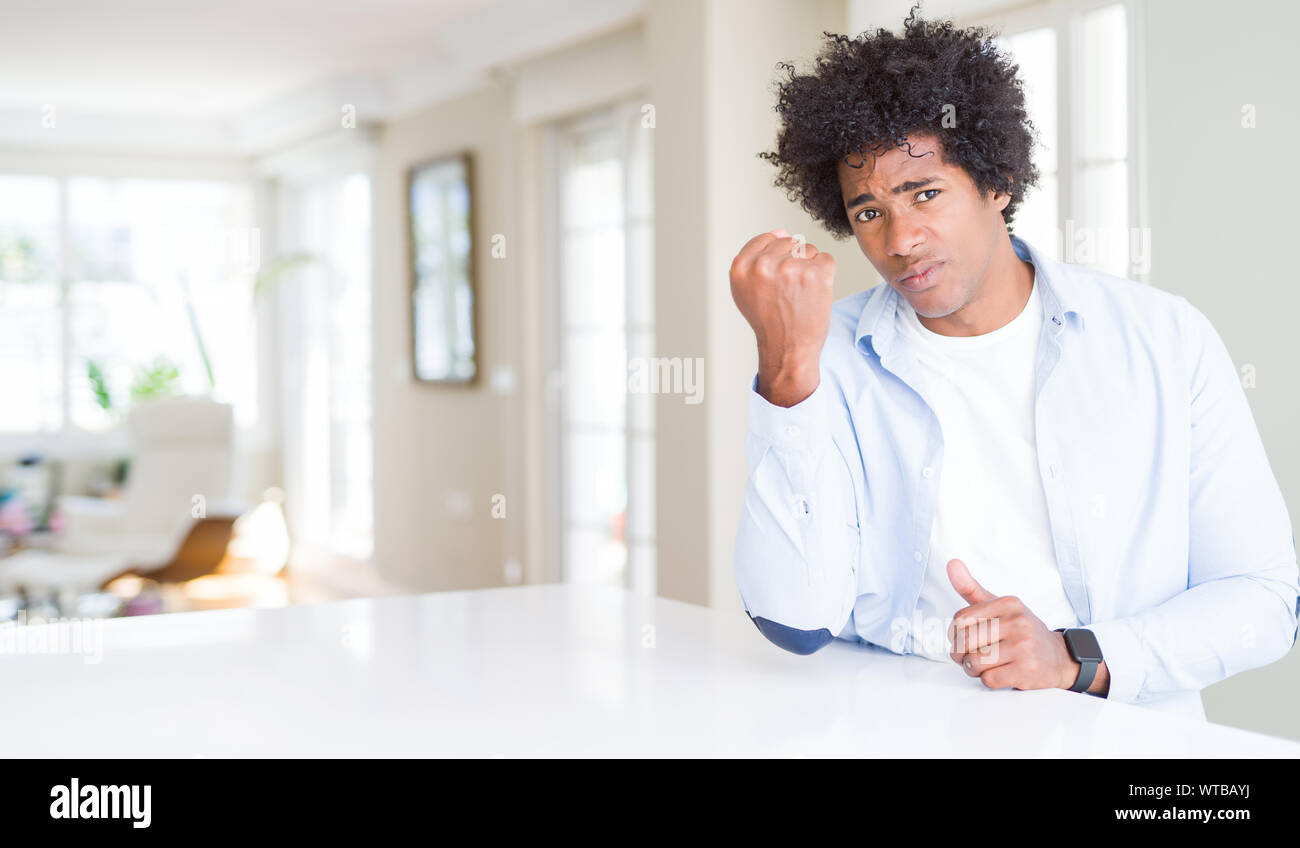 African American man at home angry and mad raising fist frustrated and ...