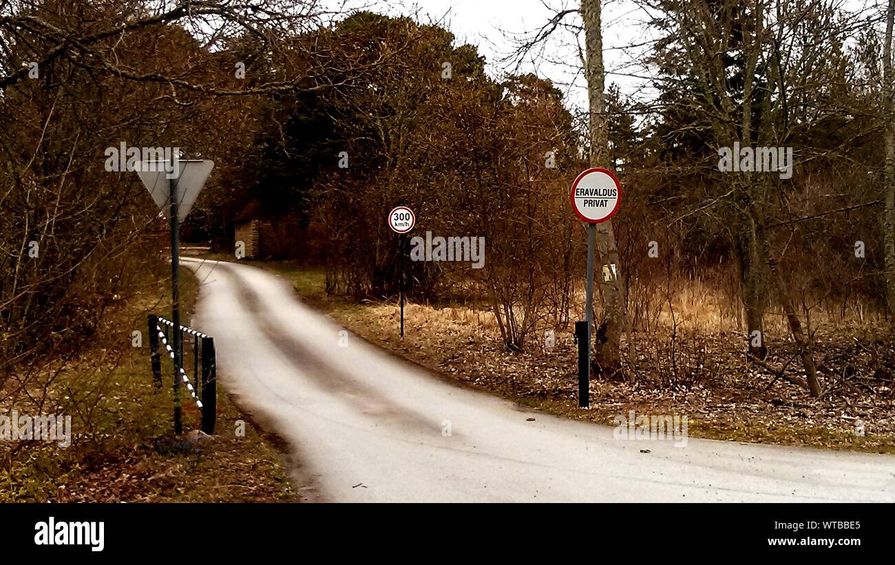 Road With Signs Against Trees Stock Photo - Alamy